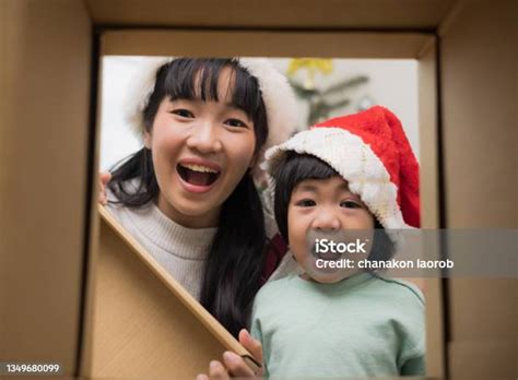 엄마와 아들은 선물 상자와 와우를 열고 있습니다 상자 안에는 크리스마스 날을위한 선물이 있습니다 아시아 가족 어머니와 아들은 상자 안에 보고 깜짝 흥분 메리 크리스마스 새해