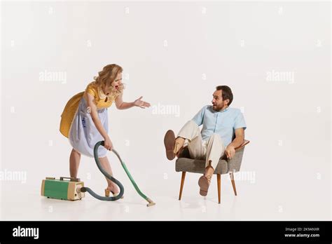 Portrait Of Young Beautiful Stylish Woman Shouting At Man While Cleaning With Vacuum Cleaner