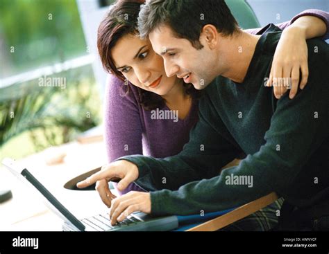Man Using Laptop Computer Woman Sitting With Arm Around Him Stock Photo Alamy