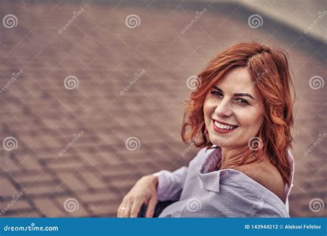 Portrait Of A Smiling Middle Aged Woman With Red Hair Stock Photo
