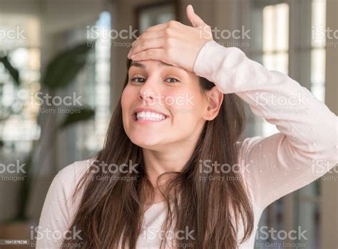 아름 다운 젊은 여자 집에서 손으로 머리에 스트레스 수치와 깜짝 얼굴로 충격 분노와 좌절 두려워 하 고 실수에 대 한 화가 갈색