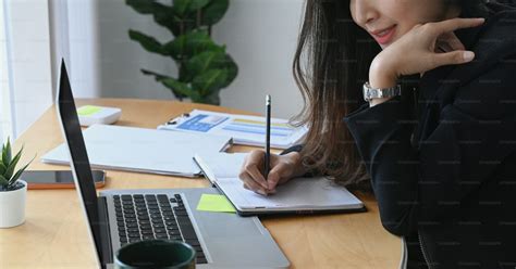 노트북 컴퓨터로 작업하고 노트북에 메모를 하는 웃는 사업가의 자른 사진 사진 Unsplash의 태국 이미지