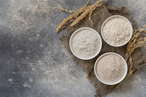 음식과 베이킹 성분 밀가루는 통밀 곡물 밀 기울기 및 밀가루에서 회색 돌 배경에 굵게 가성합니다 상단 보기 플랫 레이 공간을 복사합니다 쌀가루에 대한 스톡 사진 및 기타