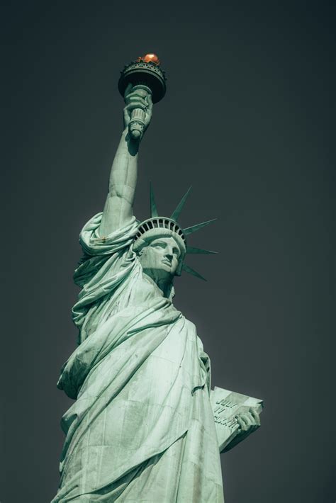 자유의 여신상을 배경으로 횃불을 들고 있는 자유의 여신상 사진 Unsplash의 무료 뉴욕 이미지
