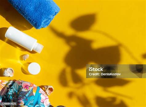 밝은 노란색 모래 배경에 수건 수영복 및 자외선 차단제를 여행자를위한 액세서리가있는 여름 배경 밝은 햇빛과 여름 배경 여행 및 휴가 개념 개념에 대한 스톡 사진 및 기타