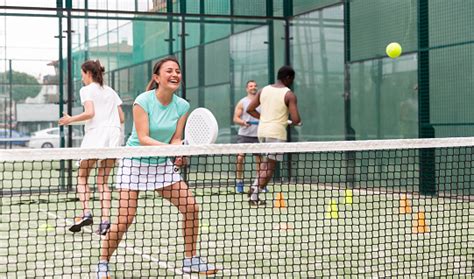 야외 에서 테니스 코트에서 파델 게임을 배우는 행복한 여자 다른 선수는 백그라운드에서 훈련 여자에 대한 스톡 사진 및 기타 이미지 Istock