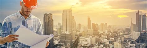 주황색 안전모를 쓴 건설 엔지니어 관리자 노동자들의 이중 노출 이미지와 배경에 도시 풍경을 오버레이하는 동안 서 있는 레이아웃 계획을 보고 있다 개념에 대한 스톡 사진 및