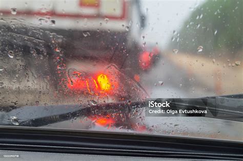 비에 흠뻑 젖은 앞 유리에서 도로의 전망 비에 서 있는 마니나 앞헤드라이트에서 적색신호 바람막이 창에 대한 스톡 사진 및 기타