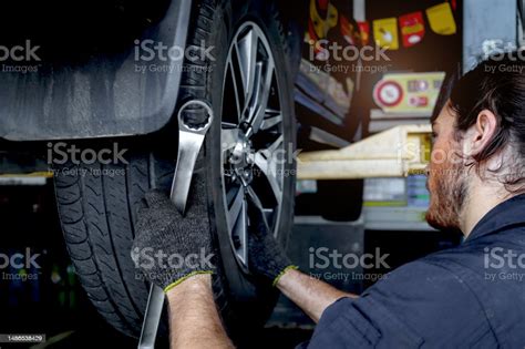 차고에서 휠 타이어를 점검하는 자동차 정비사 자동차 서비스 센터에서 고객 차량을 점검 및 수리하는 자동차 서비스 기술자 차량 수리차 정비소 20 24세에 대한 스톡 사진 및