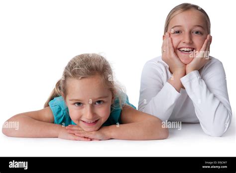 Portrait Of Two Blond Sisters Lying On The Floor On White Background With Space For Text Stock