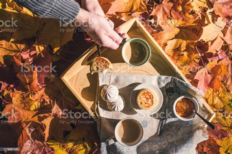 화려한 단풍 잎과 가을 정원에서 아침 식사를 하는 남자와 여자의 커플 커피 한 잔 마시멜로 잼 치즈 팬케이크를 나무 트레이에