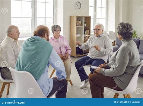 Group Of Elderly People Talking On Therapy Session At Nursing Home