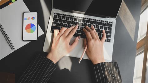 스마트 폰에서 비즈니스 차트를 보면서 노트북에서 일하는 사업가의 최고 보기 개념에 대한 스톡 사진 및 기타 이미지 개념 개념과 주제 그래프 Istock