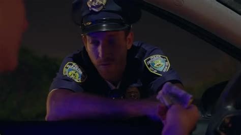 Police Officer Leans On A Car Window At Night Discreetly Accepting A