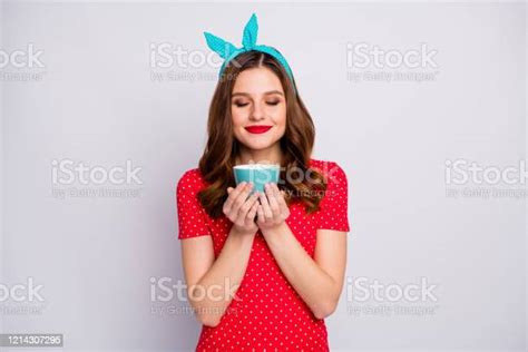 긍정적 인 쾌활한 빨간 머리 소녀의 초상화는 회색 색상 배경 위에 고립 된 빈티지 스타일의 의류를 입고 컵 닫기 에서 향기로운 카푸치노 냄새를 즐길 수 있습니다 T 셔츠에