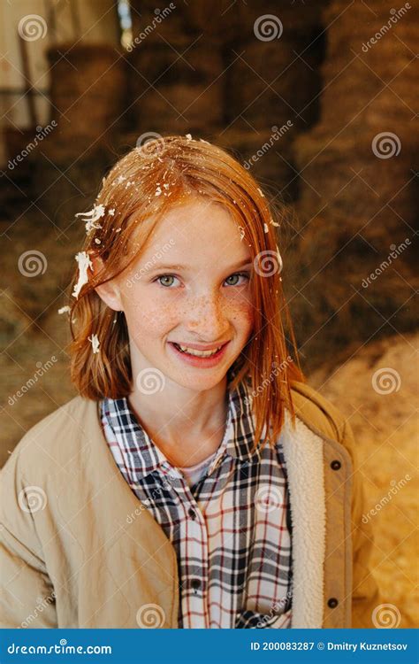 Funny Ginger Girl With Wood Shavings On Her Hair Inside Big Barn Stock