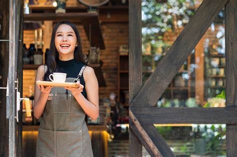 커피 숍 손 앞에 서있는 아시아 행복한 여성의 초상화 커피 숍 손 서빙 커피 컵 중소기업 환영과 함께 다시 열고 아시아 여성
