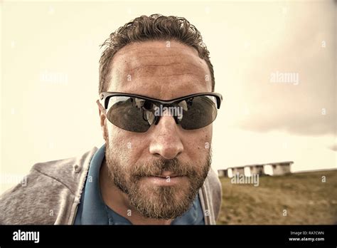 Macho With Unshaven Face Beard And Mustache In Black Sunglasses On Natural Landscape