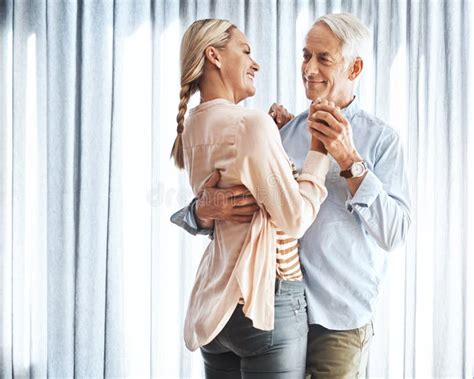 Mature Couple Dance And Hug In Home For Bonding Relationship And