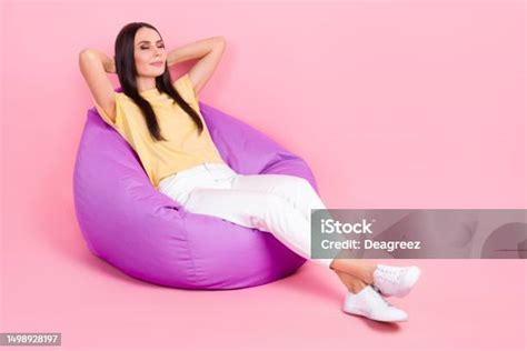 반짝이는 꿈꾸는 여자의 전체 길이 사진 노란색 티셔츠 머리 뒤에 빈 가방 팔 뒤에 앉아 빈 공간 격리 된 핑크 컬러 배경 30