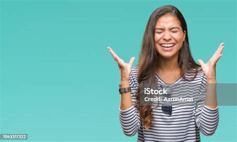 젊은 아름 다운 아랍 여자 미친과 미친 비명 제기 및 닫힌 눈 흥분 하는 무기와 성공에 대 한 격리 된 배경 위에 선글라스를 착용 우승자 개념 기이함에 대한 스톡 사진 및