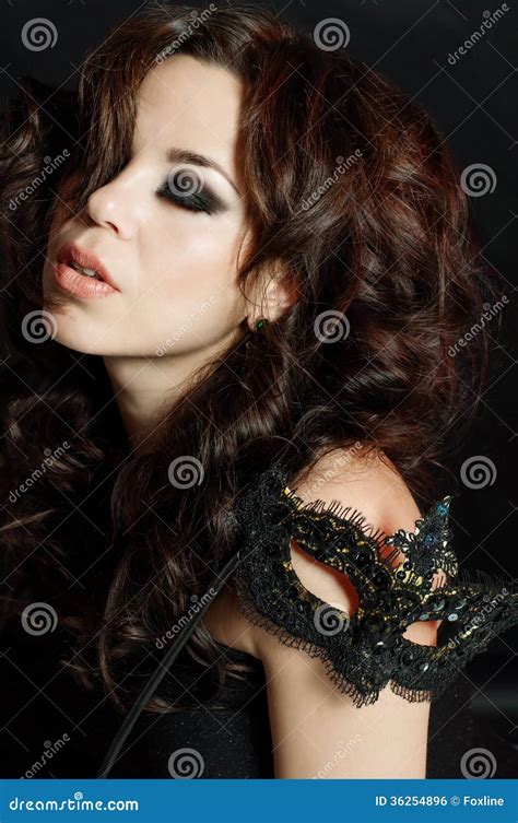 Девушка с курчавыми темными волосами и с маской масленицы Стоковое Фото