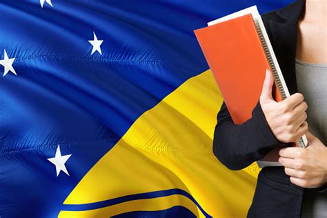 학습 언어 개념입니다 백그라운드에서 토켈라우 플래그와 함께 서 있는 젊은 여자 책을 들고 교사 오렌지 빈 책 표지 교사 교육