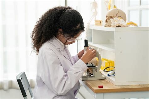 Premium Photo Lab Worker Using Magnifying Glass On Microscope