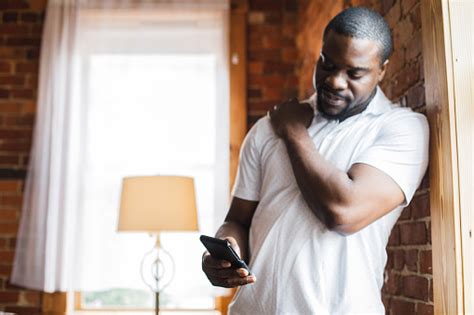 벽돌 벽에 기대어 서서 어깨를 긁고 스마트 폰을 스크롤하는 남자 흑인 민족에 대한 스톡 사진 및 기타 이미지 흑인 민족 40 44세 남자 Istock