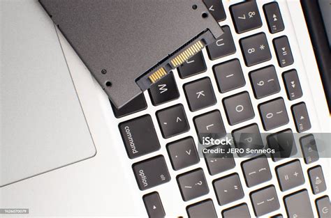 회색 노트북 위에 Ssd 고속 스토리지 Ssd가 있는 컴퓨터 개념 기술 정보학 성과 및 혁신 및 성능 흰색 표면 포트와 골든 연결을 갖춘 Ssd 0명에 대한 스톡 사진 및
