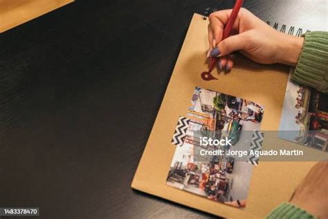 알아볼 수 없는 젊은 여성의 손이 수제 크래프트 앨범에 마커 펜으로 글을 쓰고 여행 사진과 와시 테이프가 빨간색 위치 표시를 합니다 스크랩북에 대한 스톡 사진 및 기타