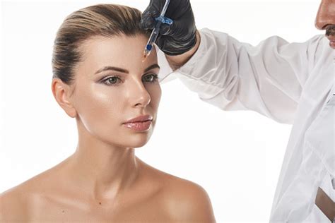 아름다운 여성의 얼굴과 의사의 미용사 또는 성형 외과 의사의 손주사기로 이마에 화장품 주사를 만듭니다 사출 미용학 개념에 대한 스톡 사진 및 기타 이미지 Istock