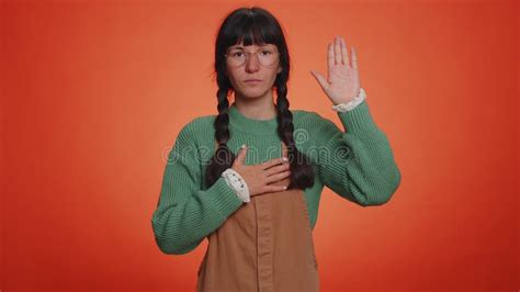 Sincere Responsible Young Nerd Woman Raising Hand To Take Oath Promising To Be Honest Tell