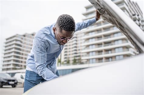 현대 건물 근처의 도시 환경에서 자동차 엔진을 검사하는 남자 가정 생활에 대한 스톡 사진 및 기타 이미지 가정 생활 거리 건물 외관 Istock
