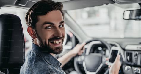 청년은 자동차 대리점에서 새 차량을 선택하고 미소를 지으며 카메라를 바라보고 있습니다 사진 Unsplash의 우크라이나 이미지