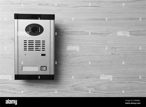 Modern Intercom System With Camera On White Wooden Background Top View