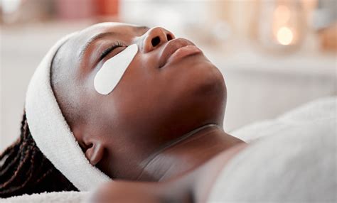 아름다움 긴장을 풀고 스킨케어 페이셜 트리트먼트 및 웰빙을 위해 스파에서 흑인 여성과 함께 아이 마스크를 착용합니다 건강 평화 및 고급 스러움과 소녀 및 얼굴 패치 화장품