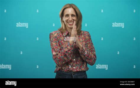 Woman Clapping Hands In Turquoise Studio Wearing Floral Blouse And