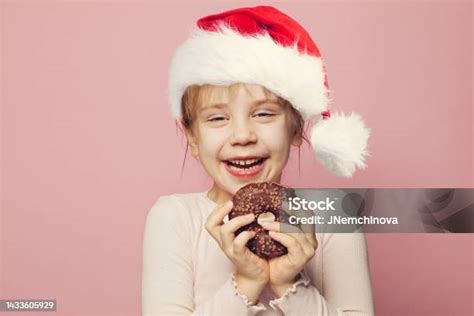 초콜릿 도넛을 들고 산타 모자에있는 귀여운 소녀 핑크 배경에 행복한 아이 12월에 대한 스톡 사진 및 기타 이미지 12월 4 5세 감정 Istock