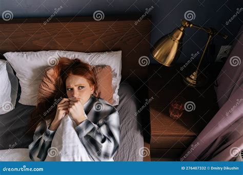 Top View Portrait Of Scared Redhead Young Woman Hiding Under Blanket