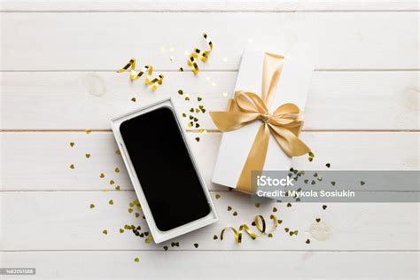 골드 리본과 스마트폰이 있는 기프트 박스를 컬러 배경 상단 보기로 오픈했습니다 빈 오픈 박스 포장 모형 디자인템플릿 브랜딩 모형