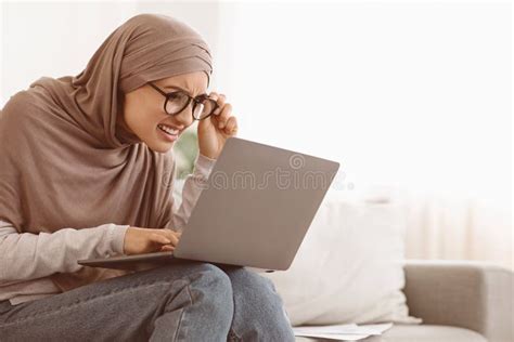 eyesight problems woman in hijab squinting eyes while looking at
