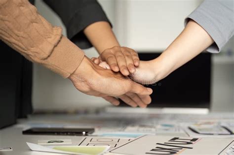Collaborative Teamwork In UX UI Design Process With Hands Stacked Over Design Documents And