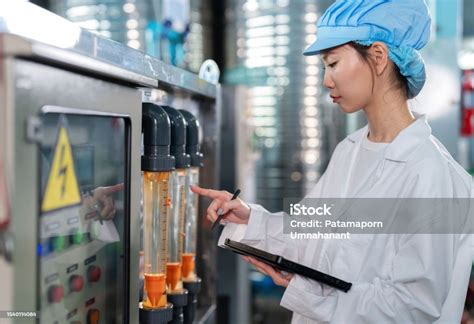 실험실 기술자가 물 공장에서 디지털 태블릿을 사용하여 정수 필터 시스템을 부지런히 점검하고 있습니다 전문성과 정밀성은 물 생산 공정의 품질과 순도를 보장합니다 분석 기술은