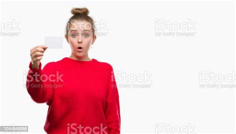 젊은 금발 여 자가 들고 광고 카드 놀라운 얼굴 두려워 하 고 공포 식으로 흥분 충격에서 무서 워 감정에 대한 스톡 사진 및 기타 이미지 Istock