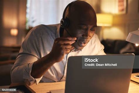 흑인 남성 야간 및 콜센터 원격 근무 및 연락 전화 통화 및 노트북 Crm을 통한 고객 서비스 헬프 데스크 및 통신 집에서 초과