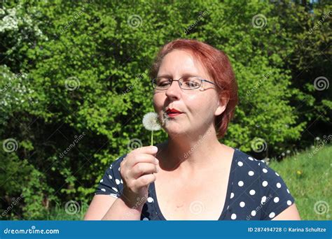 Beautiful Woman With Red Hair Blows Into Dandelion Outdoors Stock Photo Image Of Caucasian
