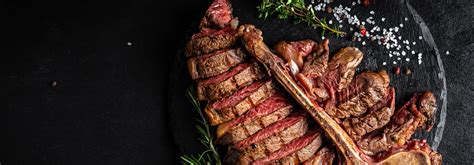 쇠고기 T본 스테이크 포크와 칼을 곁들인 중간 희귀 슬라이스 스트립로인 소고기 스테이크 미국 육류 레스토랑 배너 텍스트 케이터링 메뉴 레시피 장소 건조한에 대한 스톡 사진