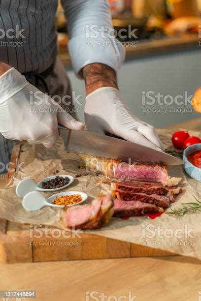 나무 주방 보드에서 구운 스테이크를 얇은 조각으로 자르는 요리사의 클로즈업 보기 40 44세에 대한 스톡 사진 및 기타 이미지