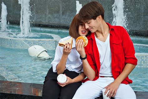 함께 야외에서 점심을 먹는 남자와 여자 햄버거와 샌드위치를 먹는 커플 패스트 푸드와 길거리 음식의 개념 종이 용기와 일회용 컵의 음식 18 19세에 대한 스톡 사진 및 기타